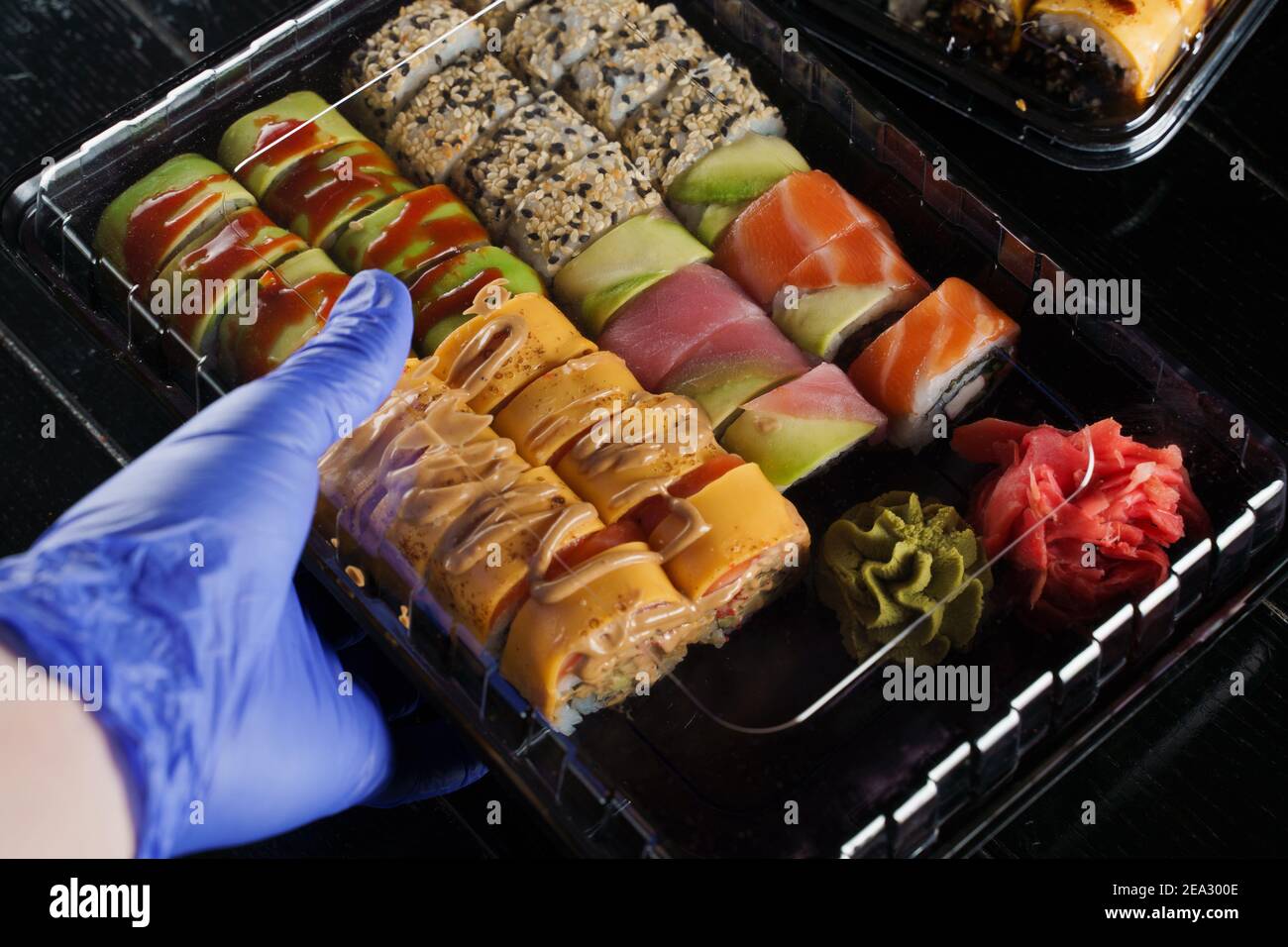 Sushi roll food delivery service at quarantine covid-19 period. Holding ...