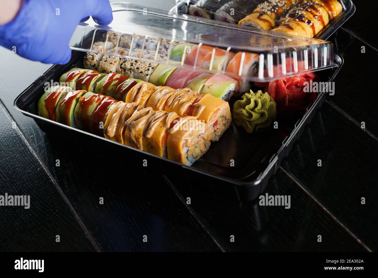 Sushi roll food delivery service at quarantine covid-19 period. Holding ...
