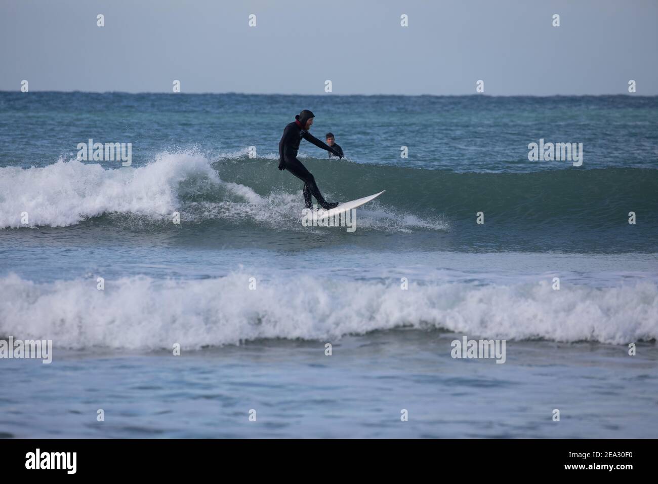 Surfers seen from St Gothian Sands in Cornwall, UK Stock Photo - Alamy