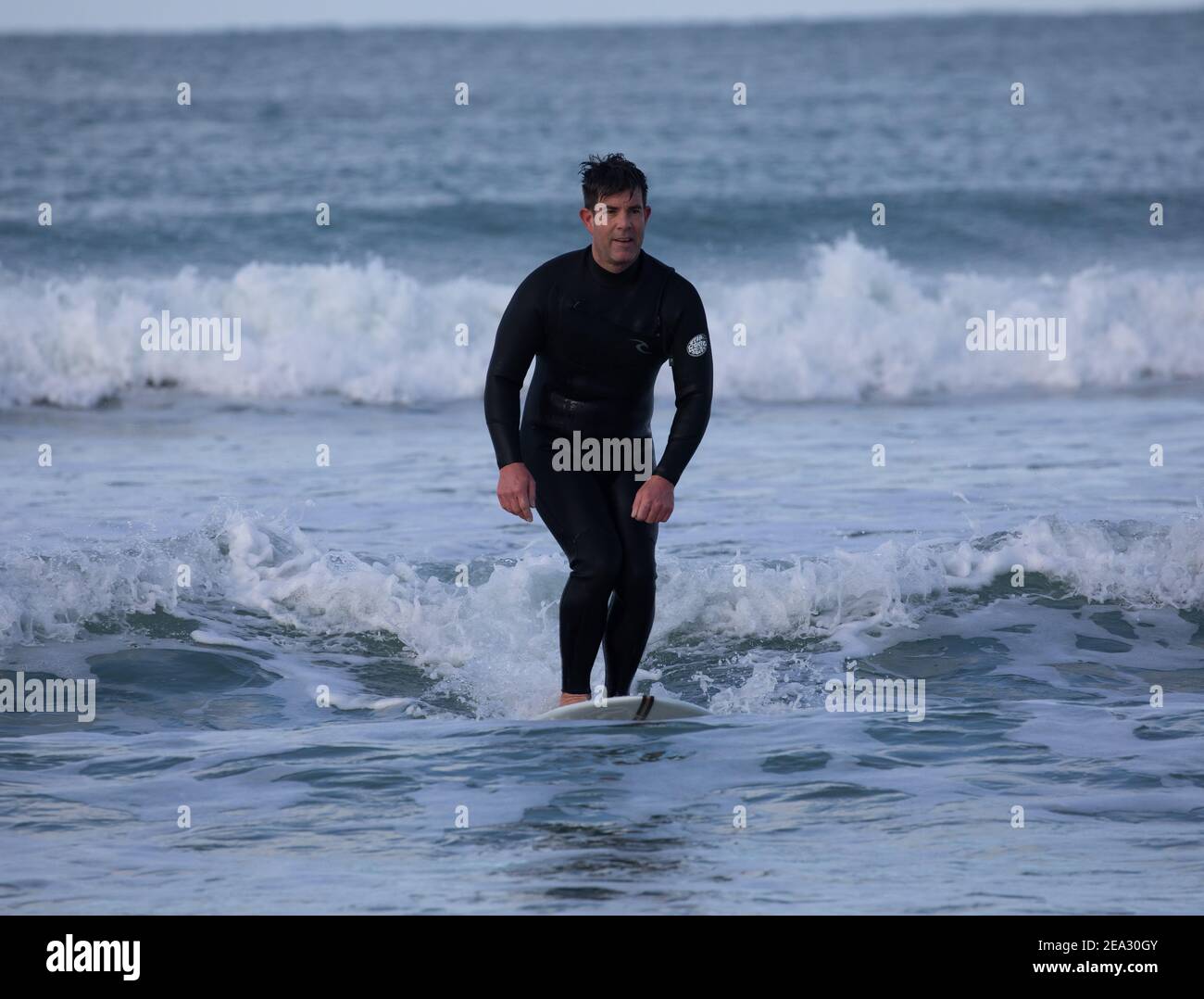 Surfers seen from St Gothian Sands in Cornwall, UK Stock Photo - Alamy