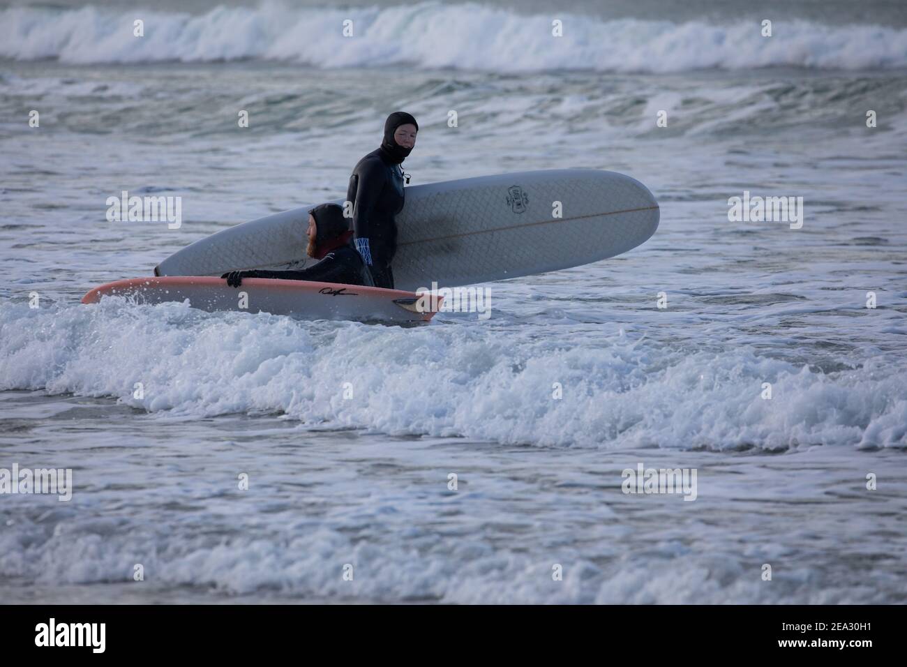 Surfers seen from St Gothian Sands in Cornwall, UK Stock Photo - Alamy