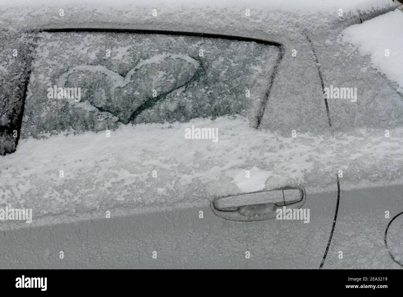 A heart on an icy car window. A heart shape in the ice on a car door ...