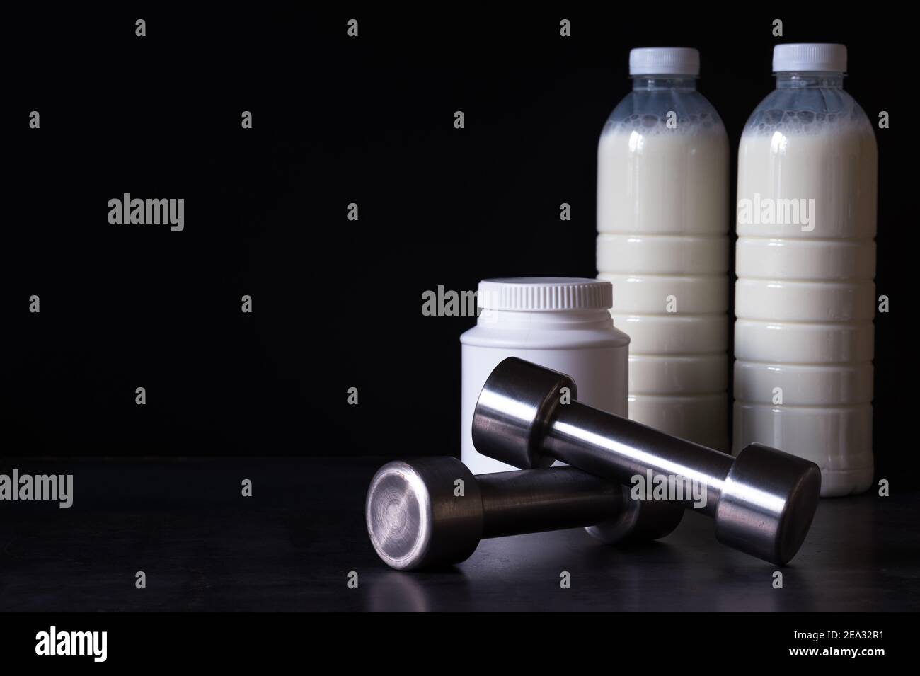 Dumbbells with protein powder and milkshake bottles in plastic ...