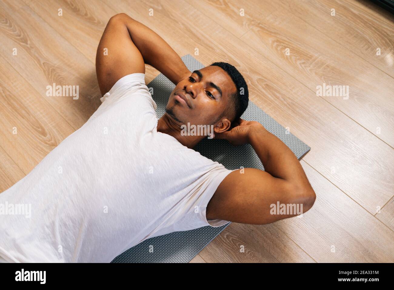 Top view of fit African-American man practicing abs crunches, training ...