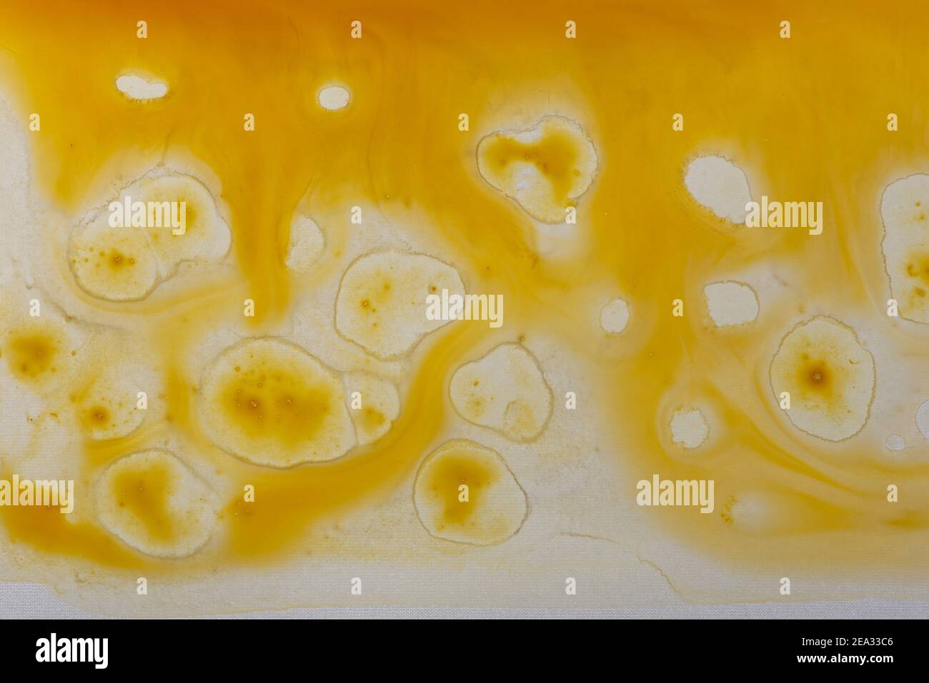 Abstract yellow paint background. Paint stains and splashes. Fluid art ...