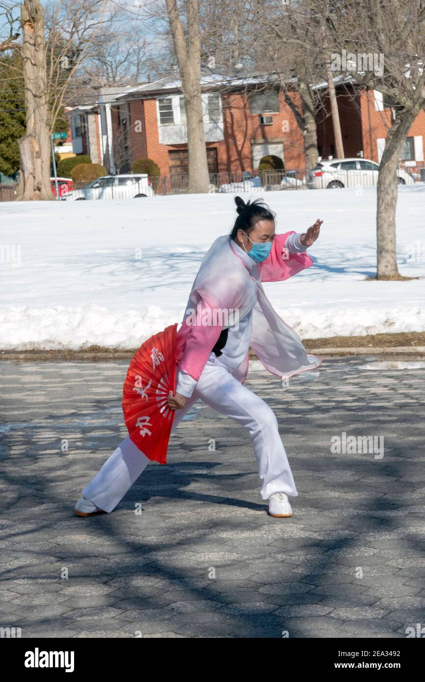 A middle aged Chinese American woman gracefully does Tai Chi dance ...
