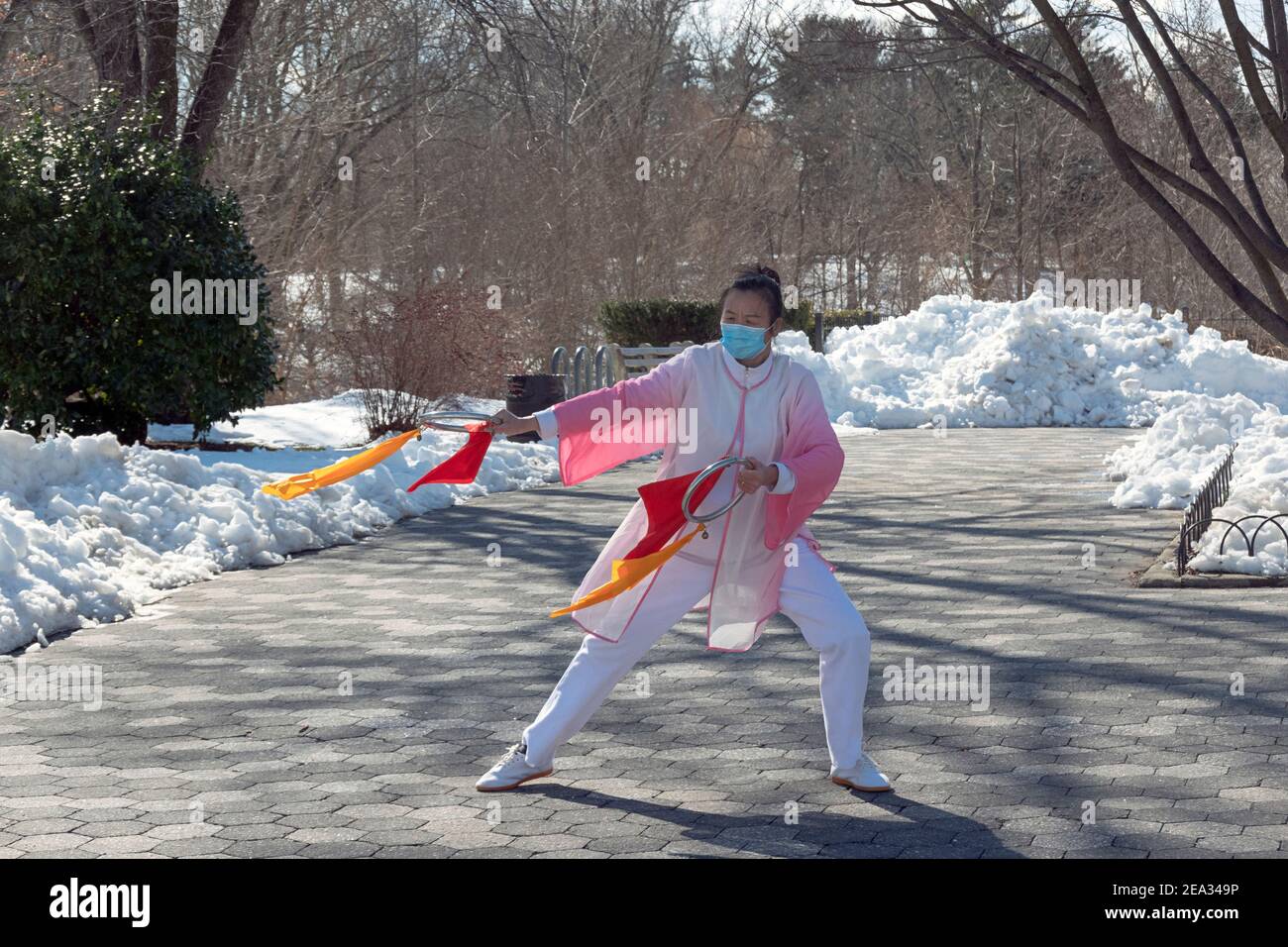 A middle aged Chinese American woman gracefully does Tai Chi dance ...