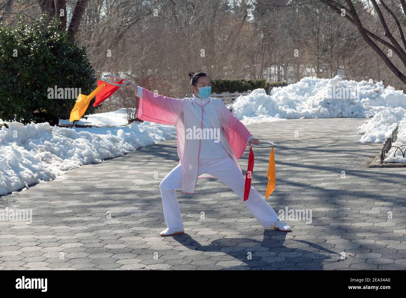 A middle aged Chinese American woman gracefully does Tai Chi dance ...