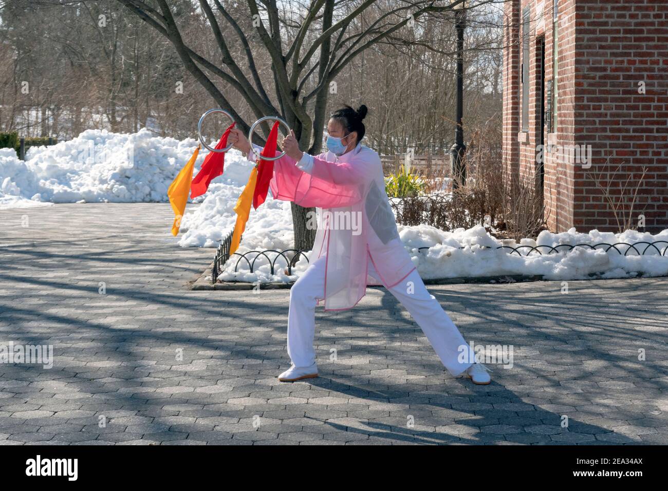 A middle aged Chinese American woman gracefully does Tai Chi dance ...