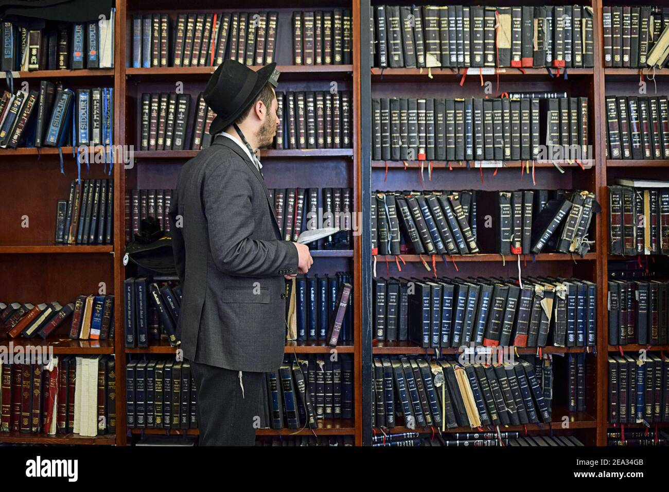 A young Jewish man prays alone at the Ohel in Queens, New York. Behind ...