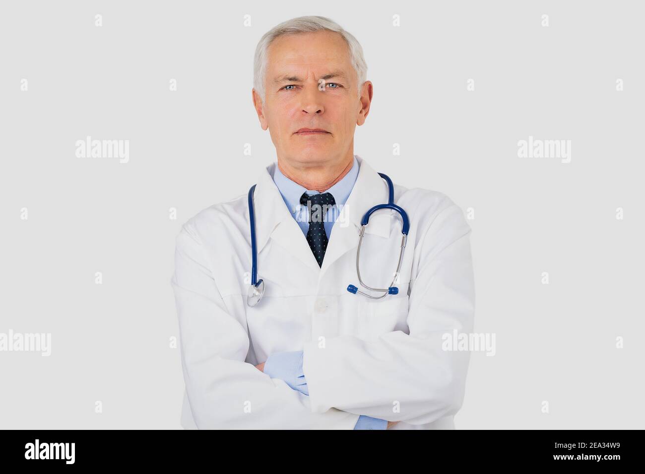 Studio portrait of senior male doctor standing at isolated white ...