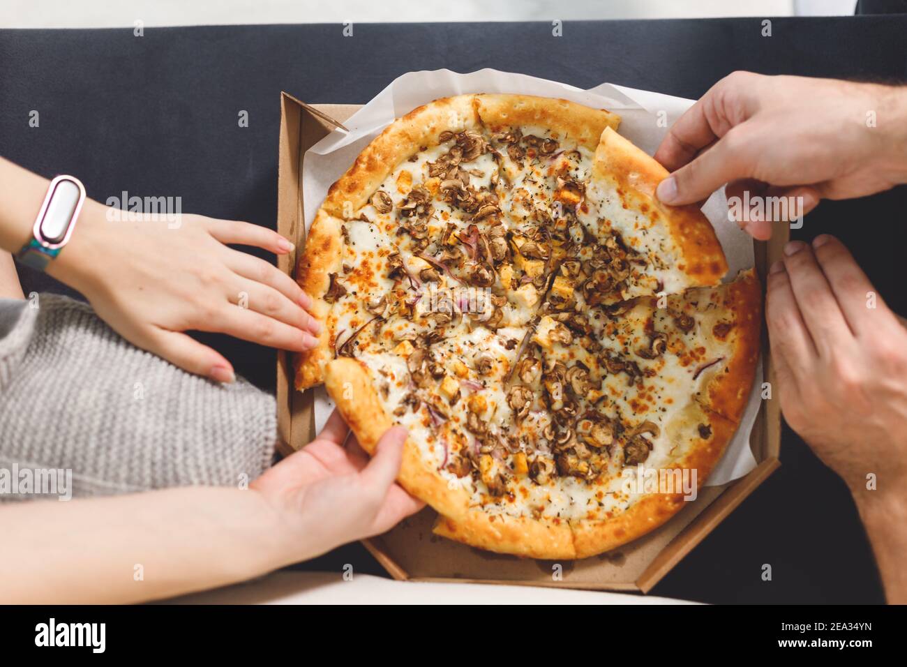 young couple eating pizza. Top view hands with pizza Stock Photo - Alamy
