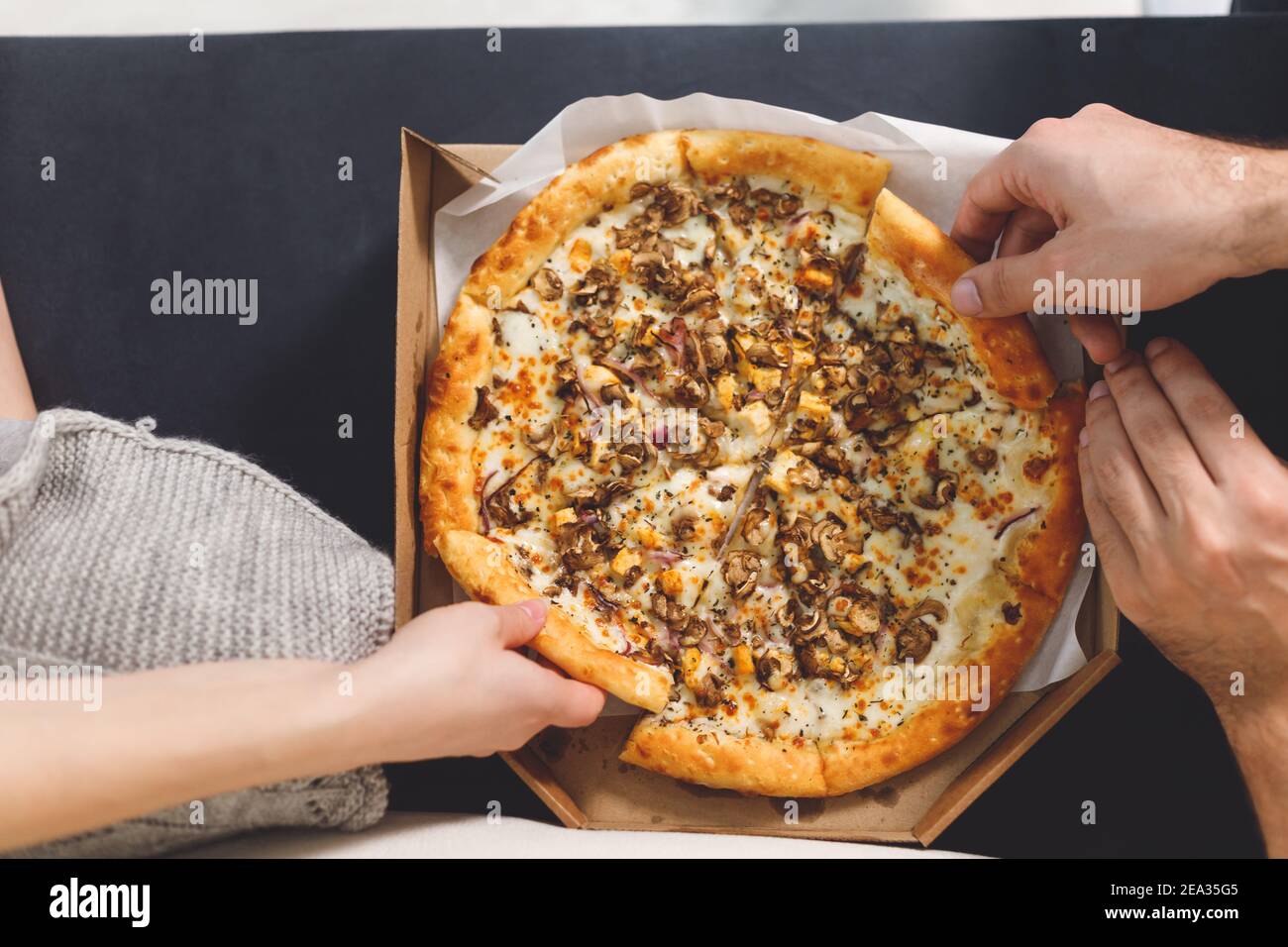young couple eating pizza. Top view hands with pizza Stock Photo - Alamy