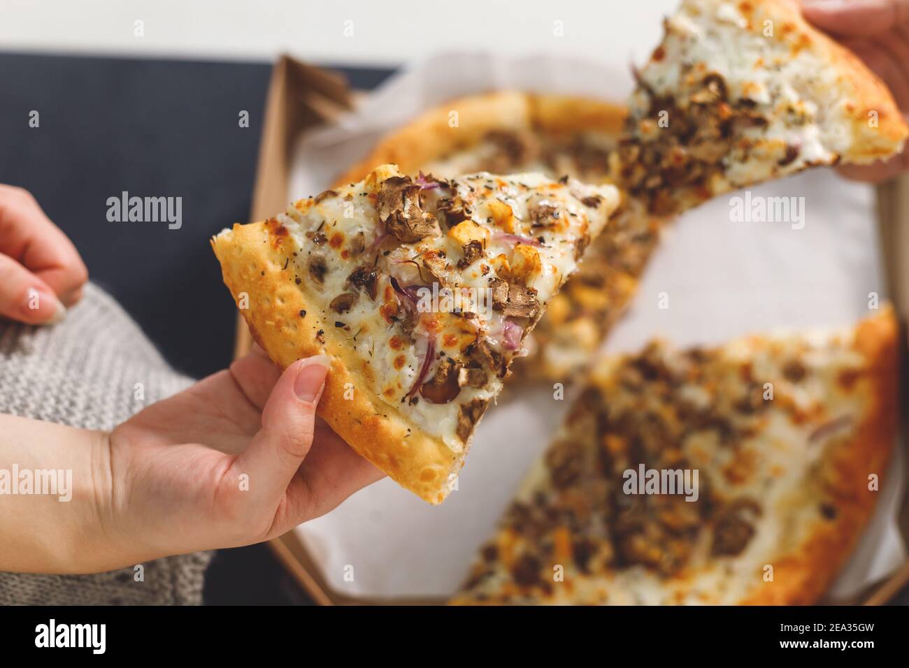 young couple eating pizza. Top view hands with pizza Stock Photo - Alamy