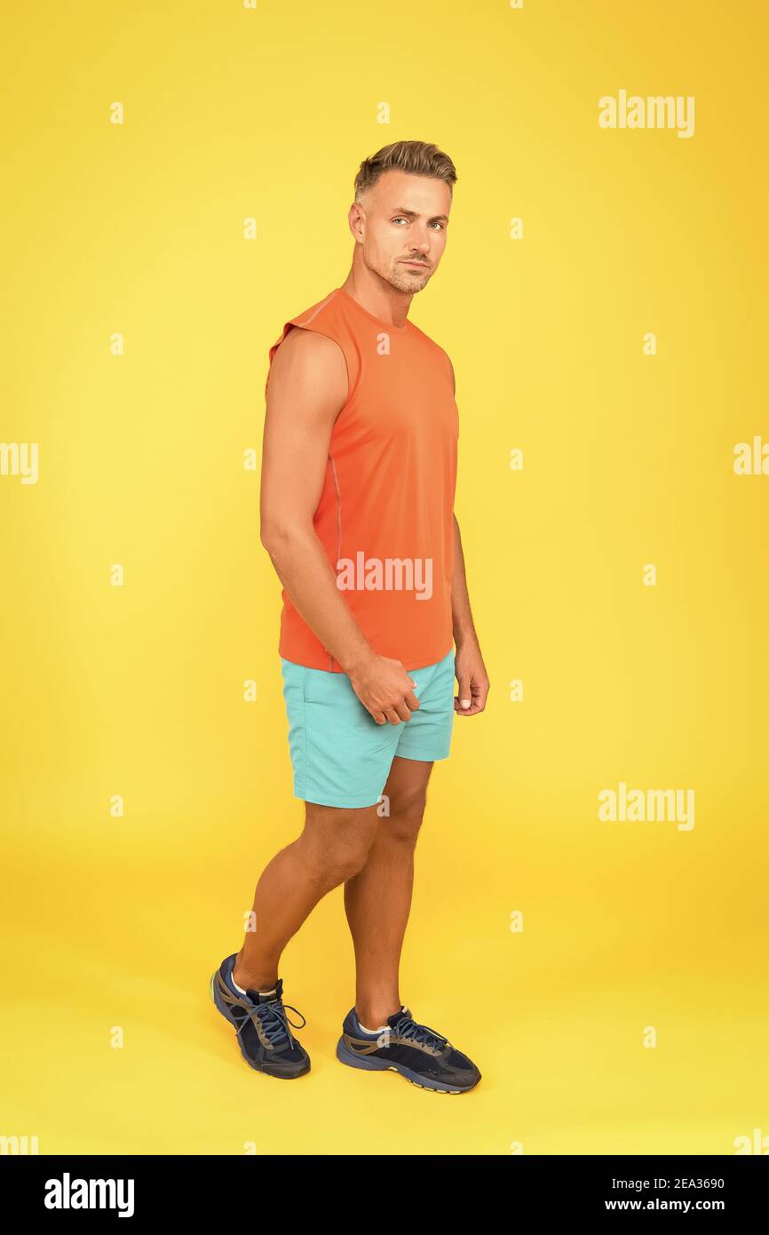 Fit body is your choice. Fit man yellow background. Strong athlete wear ...