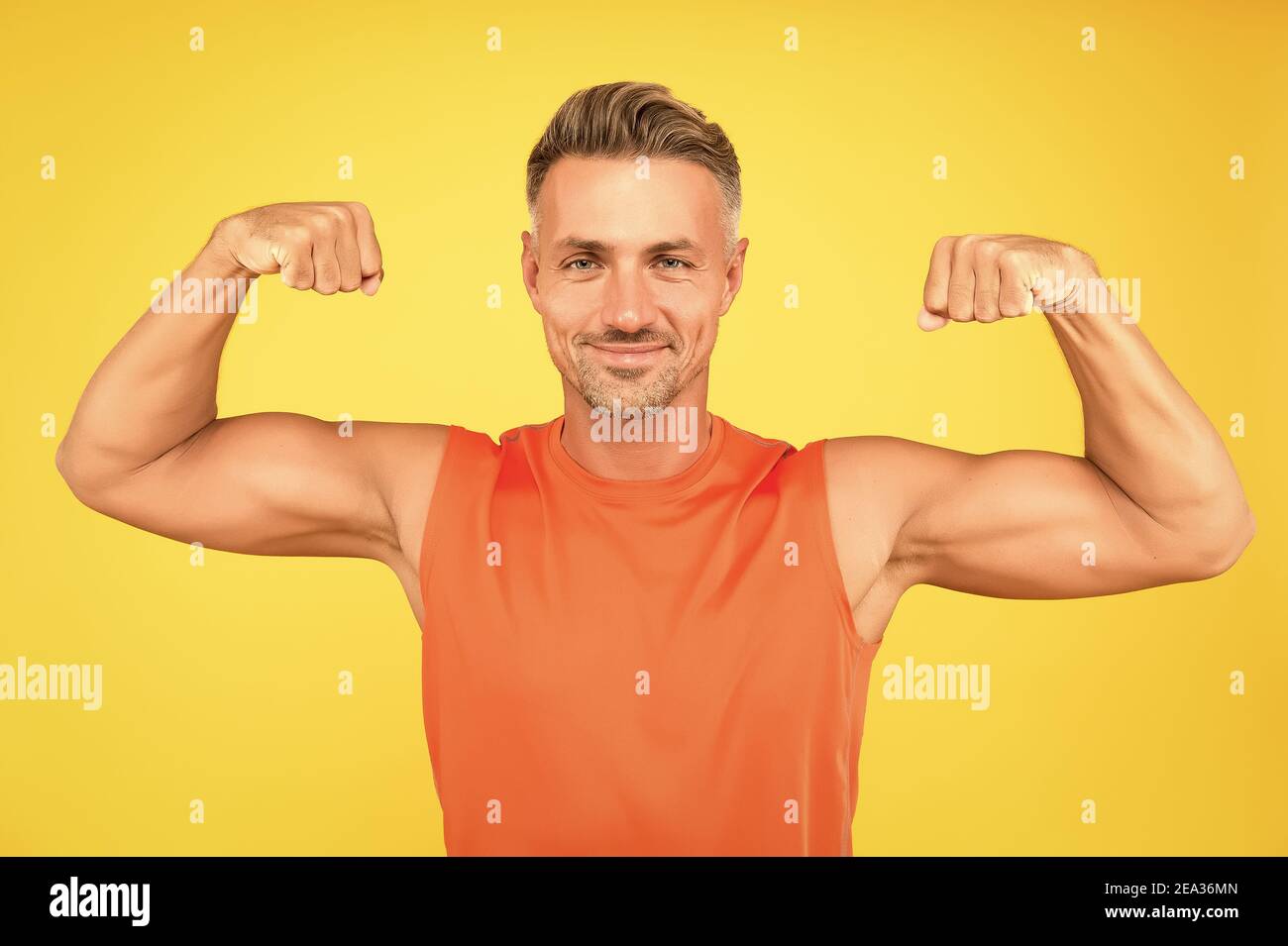 Train hard be strong. Strong man flex arms yellow background. Building ...