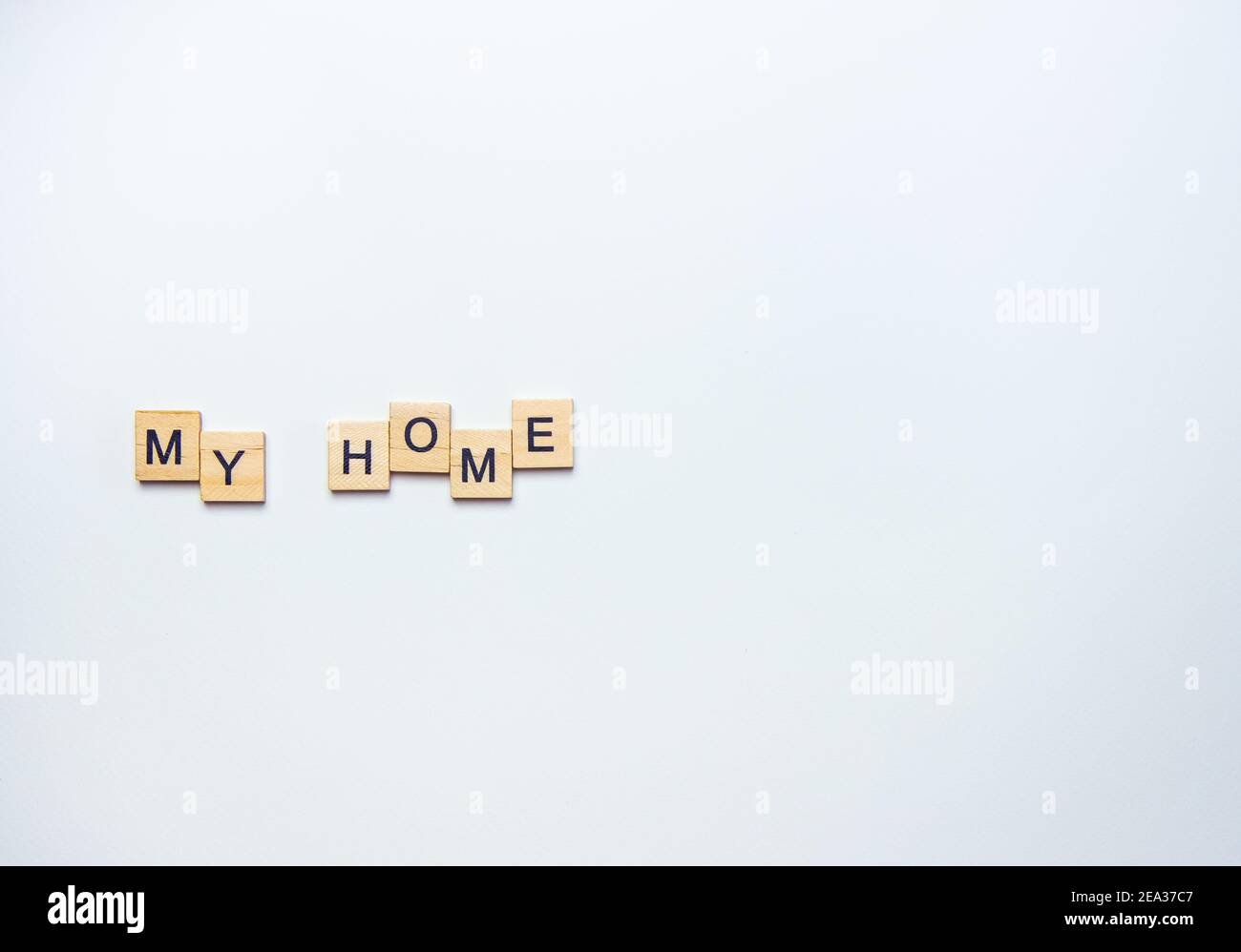 Text my home lined with wooden cubes in different positions on a white ...