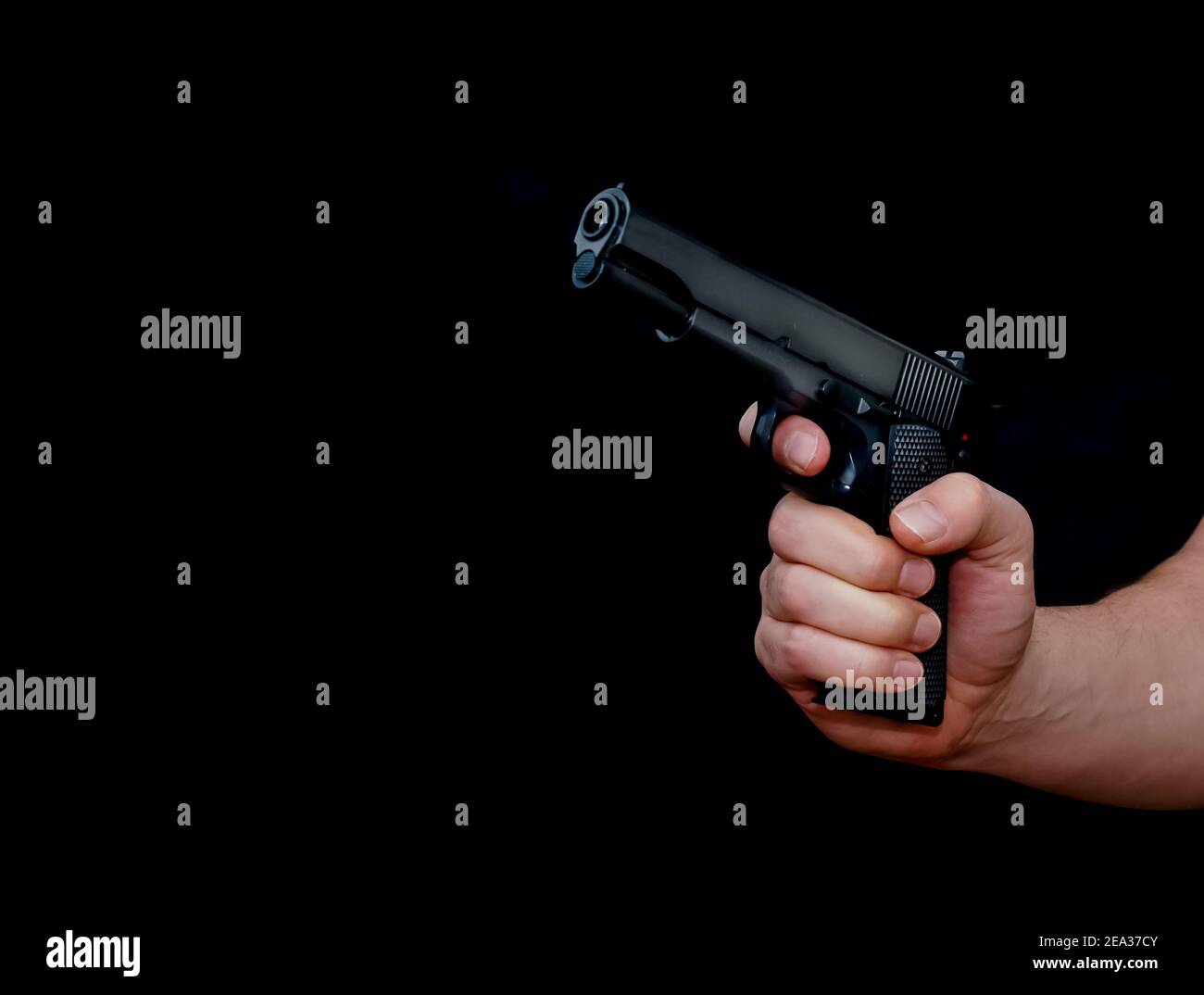 Hand holding a gun, isolated on black background Stock Photo - Alamy