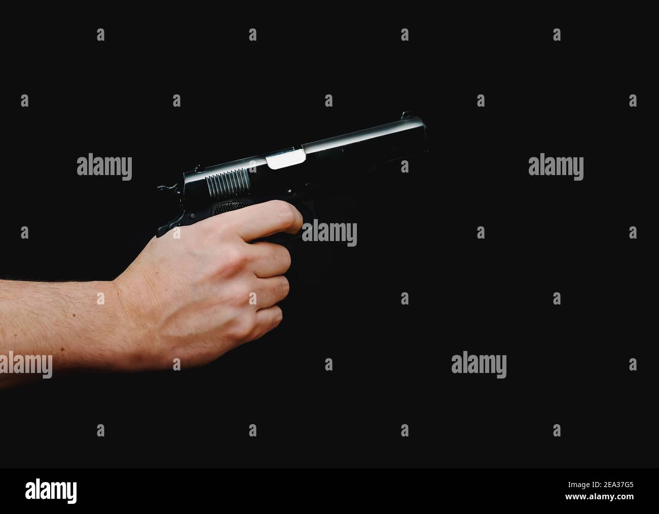 Hand holding a gun, isolated on black background Stock Photo - Alamy