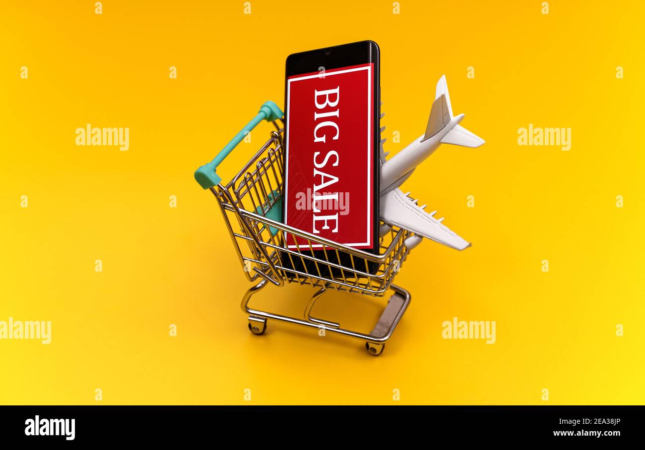 Shopping cart with plane toy. Air tickets sale concept Stock Photo - Alamy