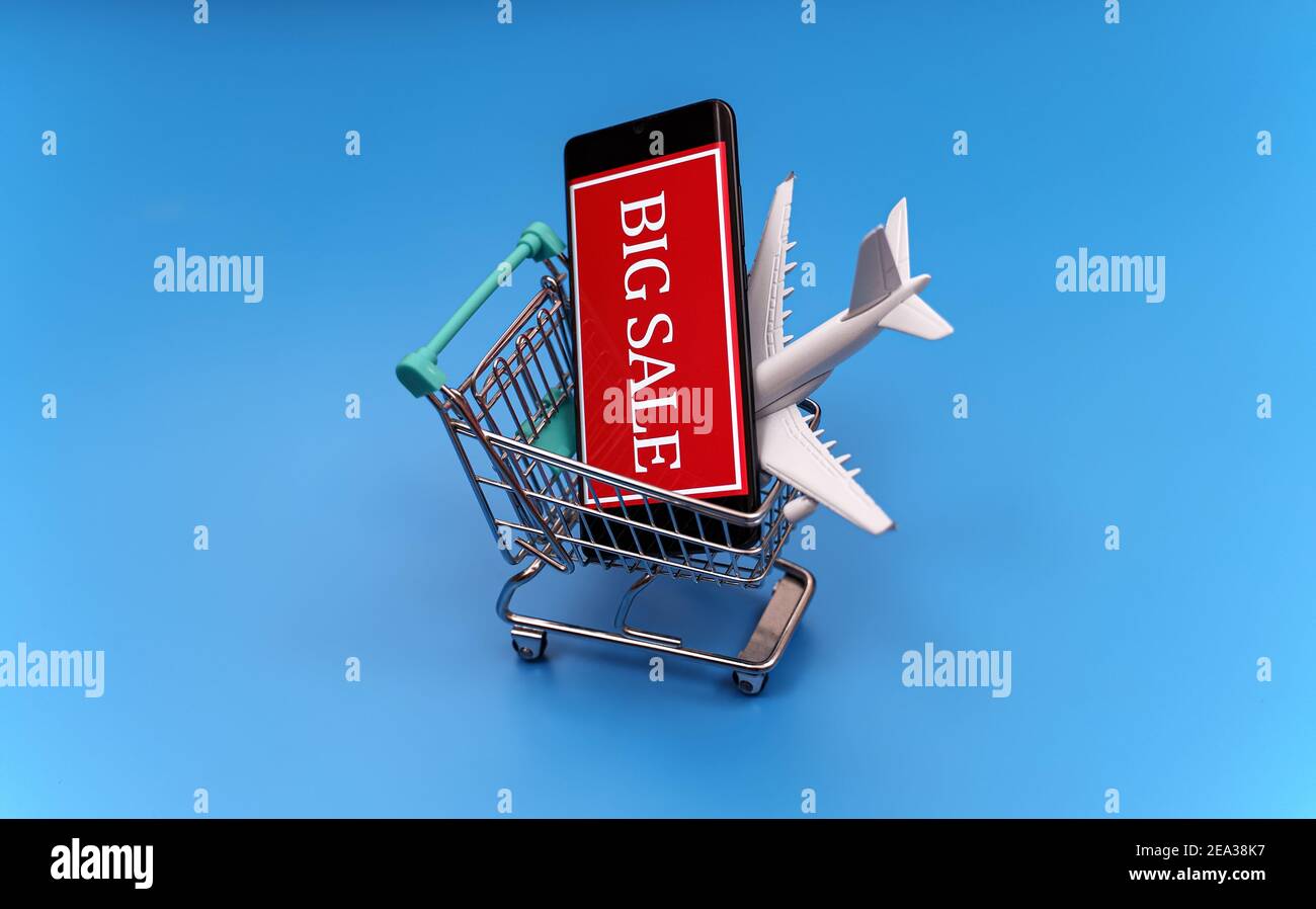 Shopping cart with plane toy. Air tickets sale concept Stock Photo - Alamy