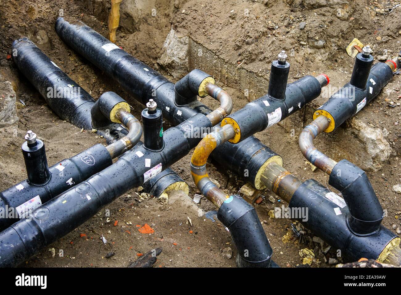 underground heating system pipes replacement on the city street, view of new thermal insulated ...