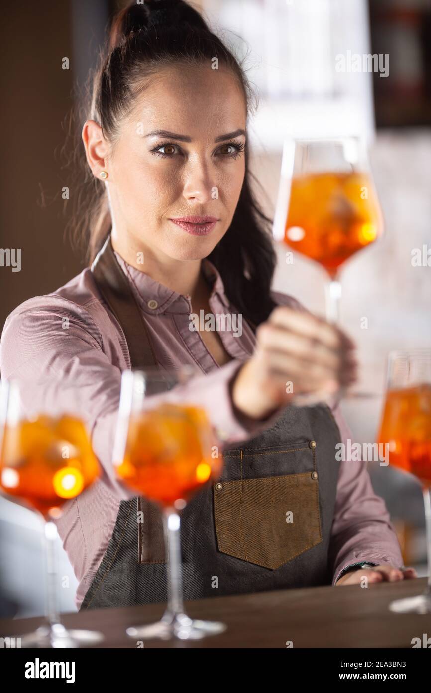 Bartender is checking the quality of an orange cocktail aperol spritz ...