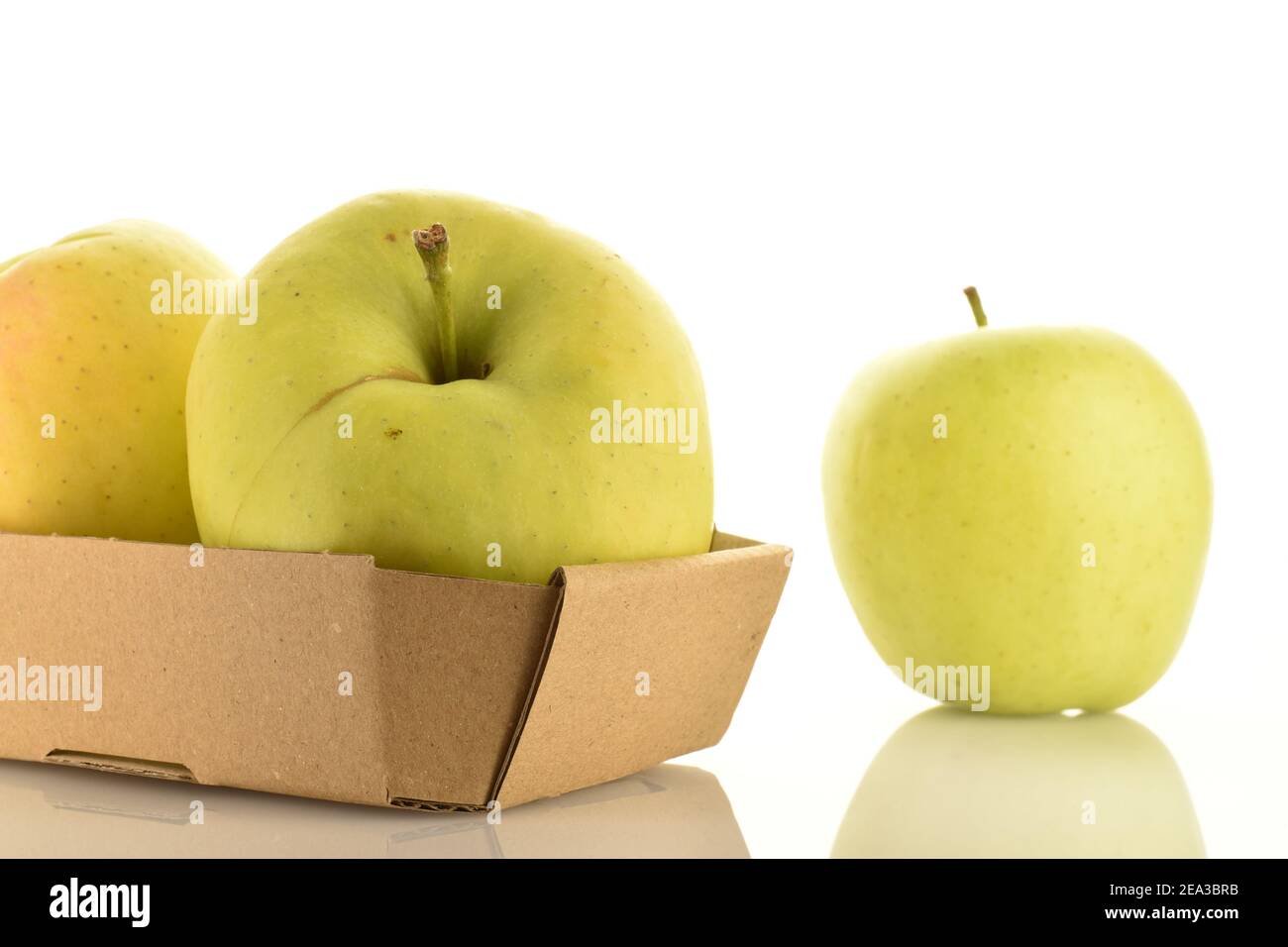 Several fresh yellow apples with a paper box, close-up, isolated on ...