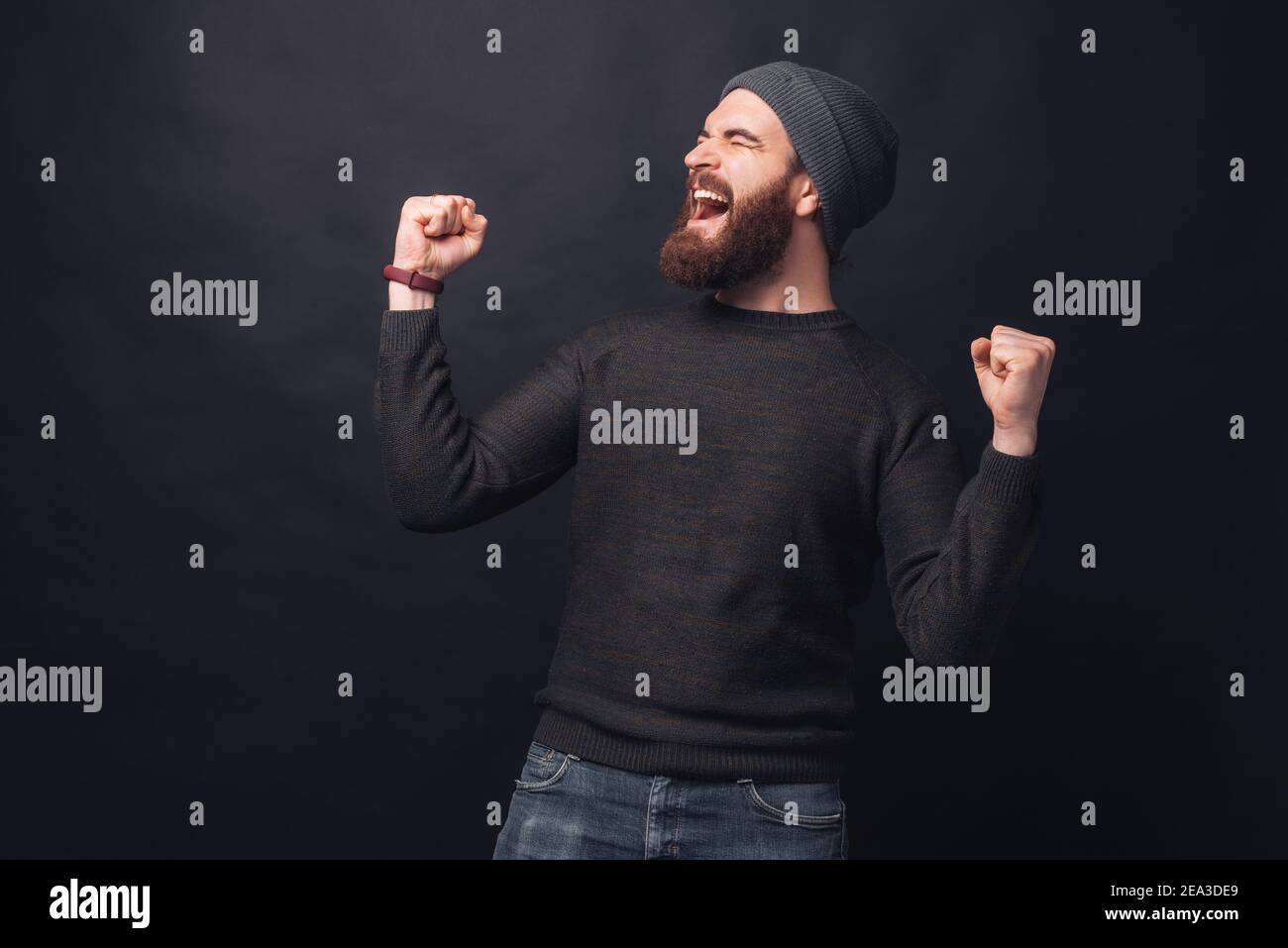 Photo of bearded man celebrating success over black background Stock ...
