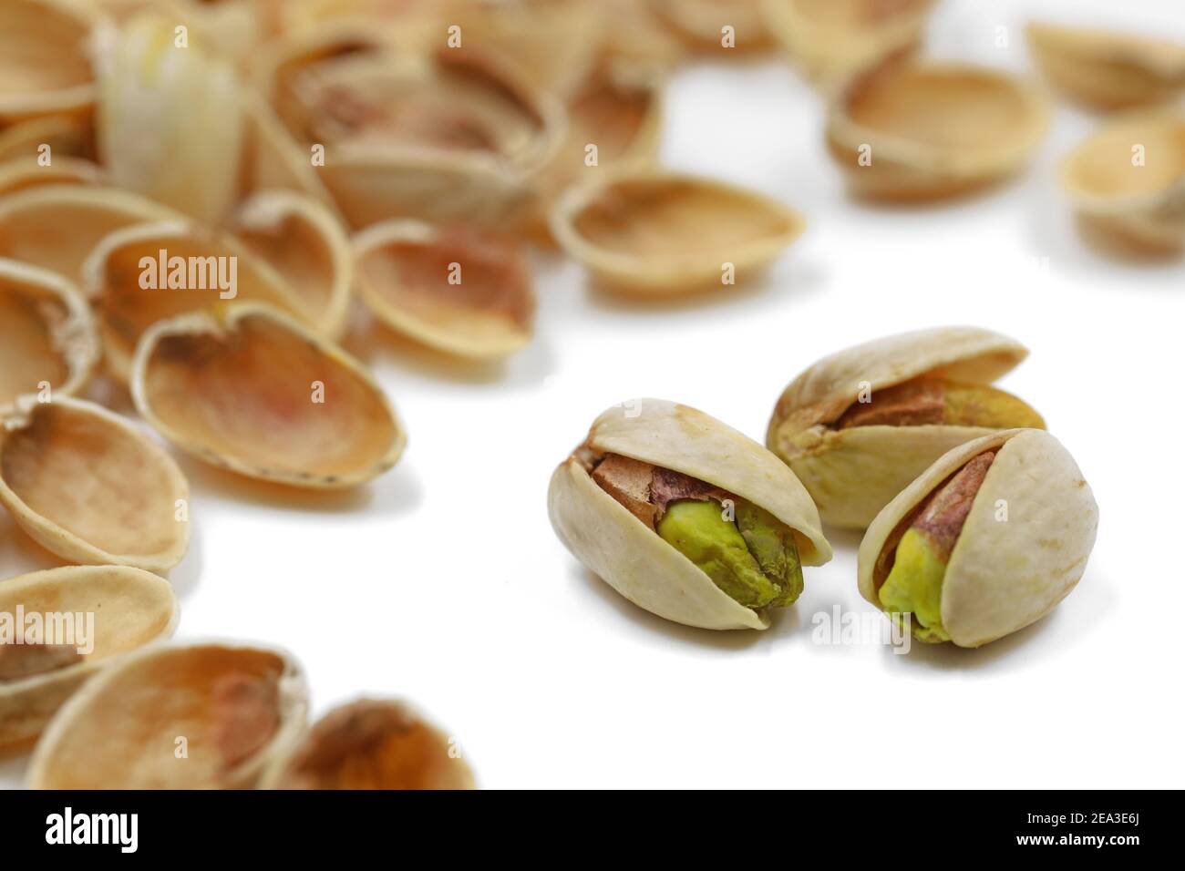 three pistachio nuts in heap of shells on a white background Stock ...