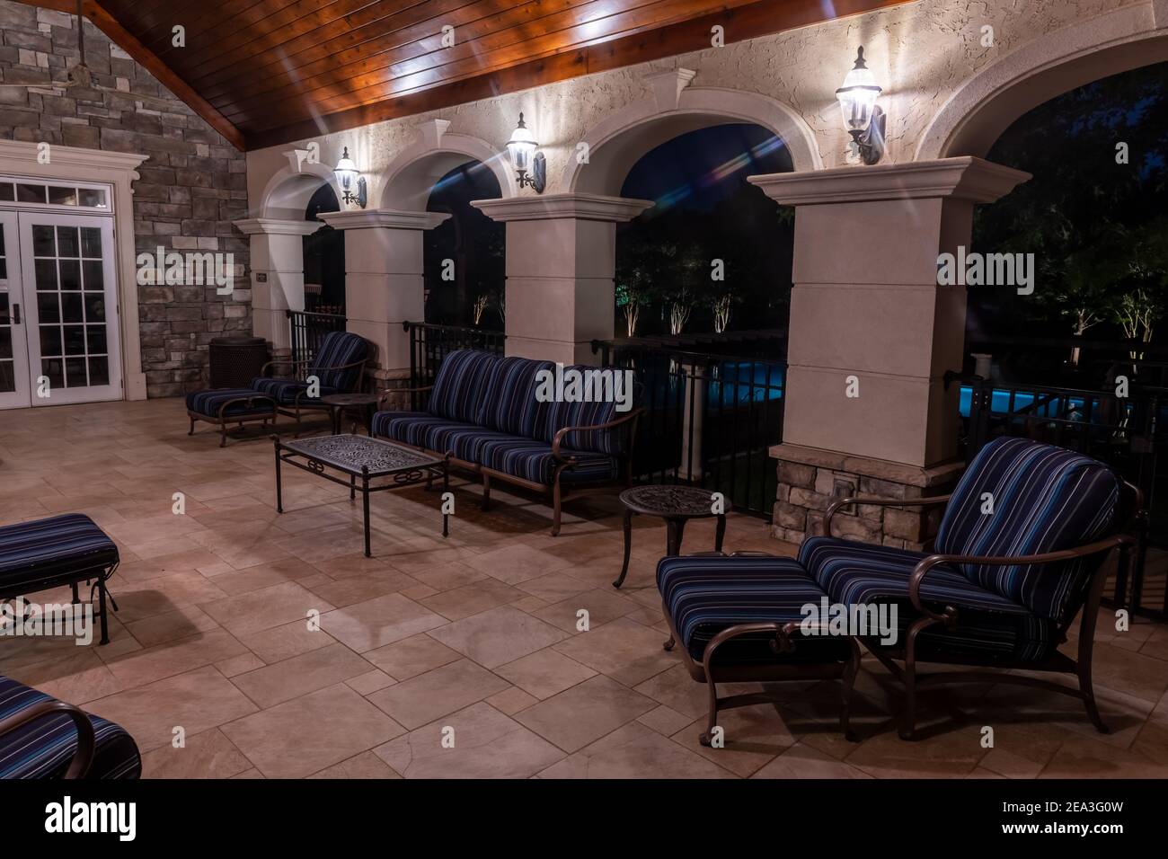 Outdoor patio over looking swimming pool at night Stock Photo - Alamy