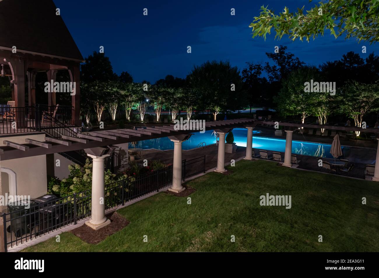 Outdoor patio over looking swimming pool at night Stock Photo - Alamy