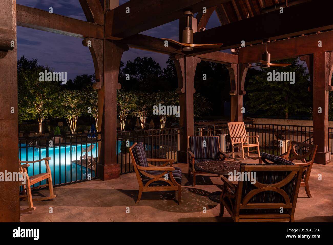 Outdoor patio over looking swimming pool at night Stock Photo - Alamy