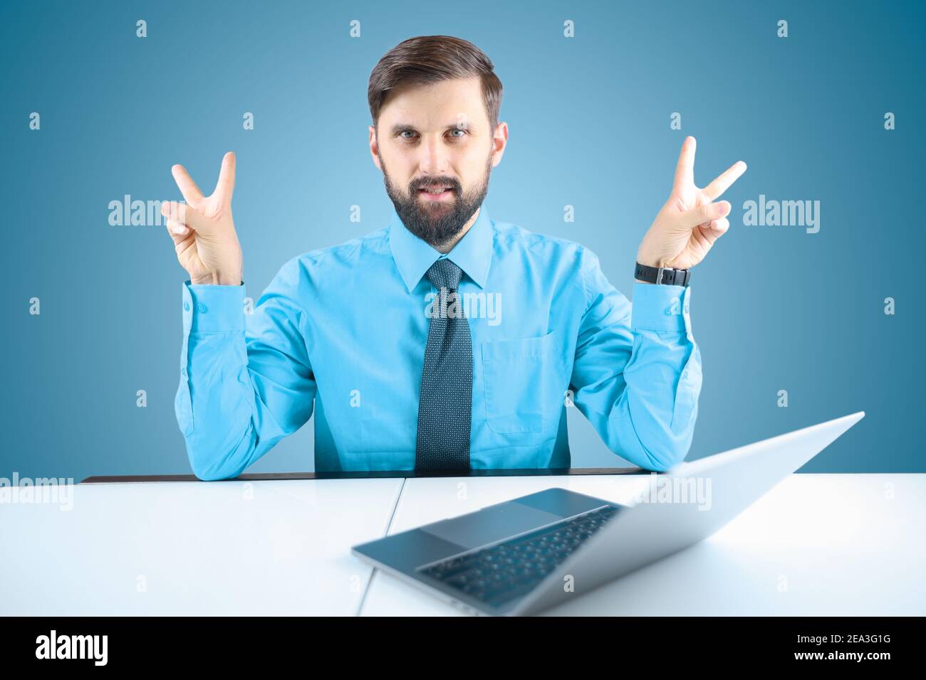 A businessman in a blue shirt and tie shows gestures with his hands, a ...