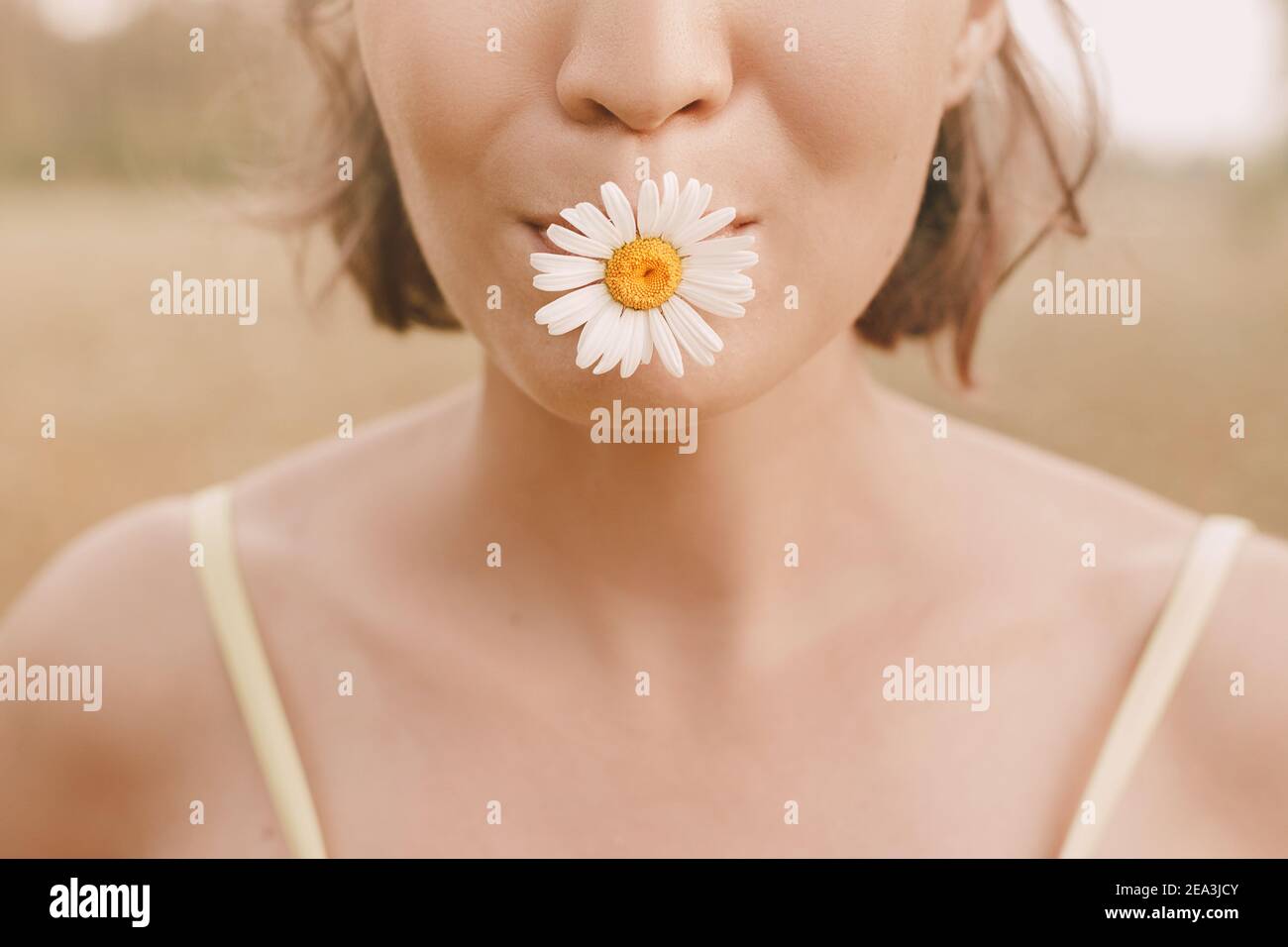 woman poses with a single Daisy as a symbol of purity and harmony with ...