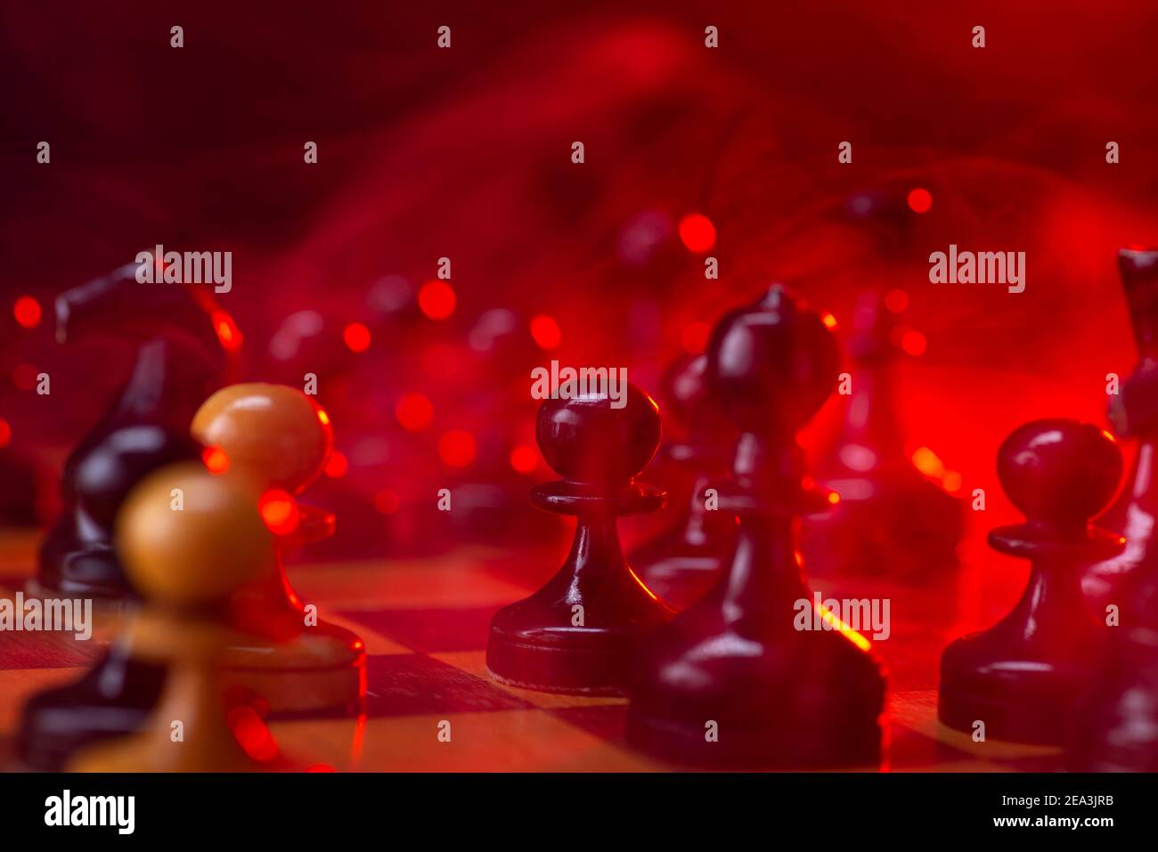 Chess fight, chess pieces on the board, toned in red. Battle fire and ...