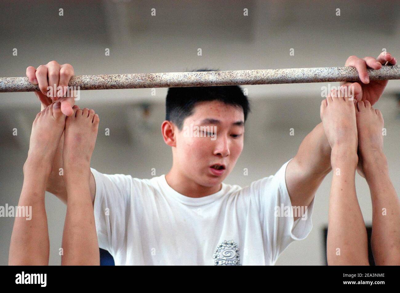 A chinese sport teacher giving training a young athlet in a Gymnastics ...