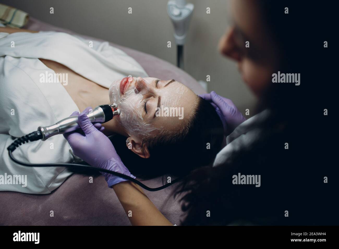 Young woman receiving electric RF lifting facial massage at beauty spa ...