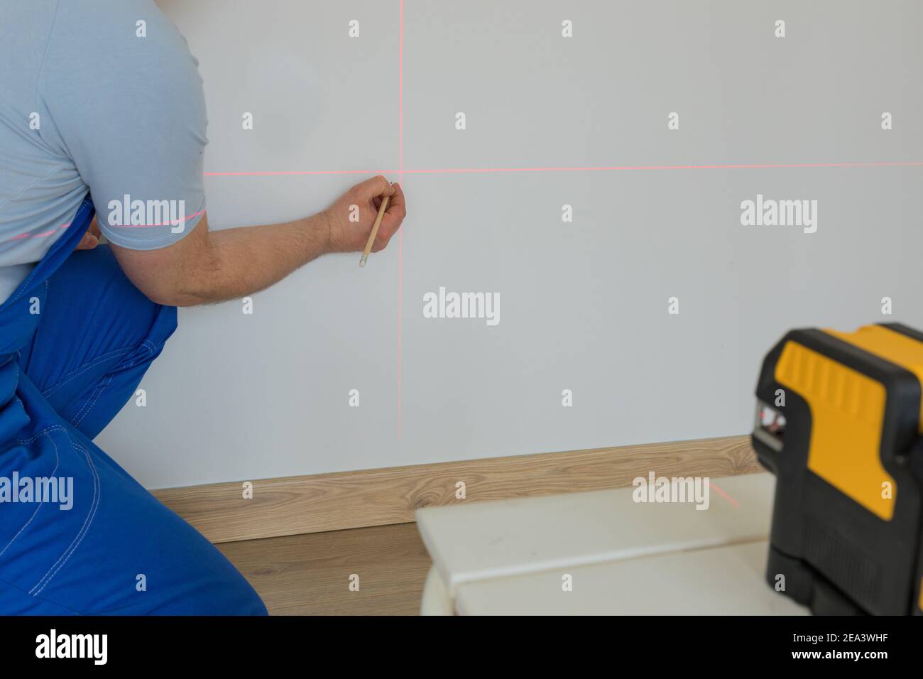 A specialist marks a point on a wall with an electronic laser Stock ...