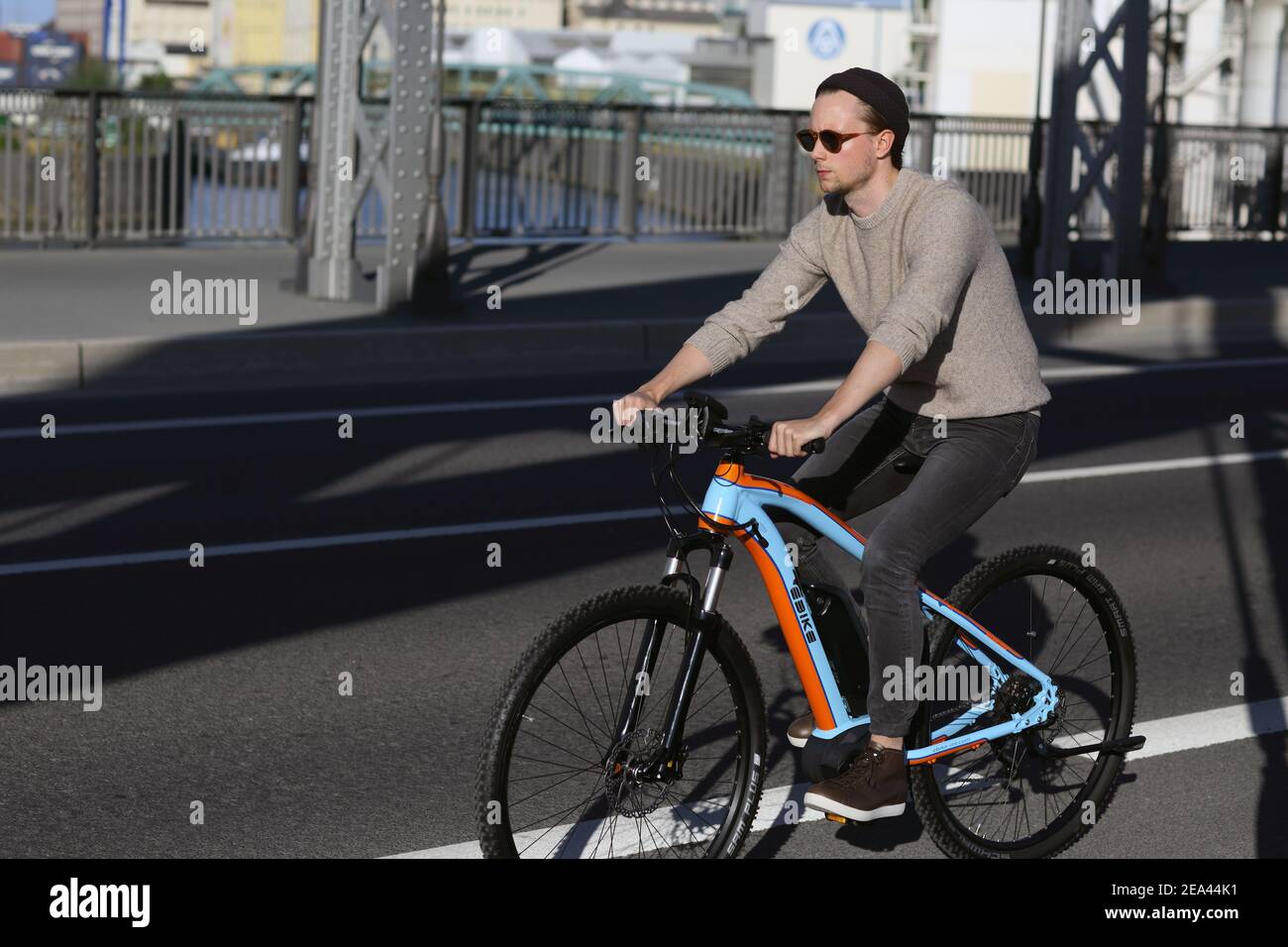 handsome young man with ebike cycling with urban background Stock Photo ...