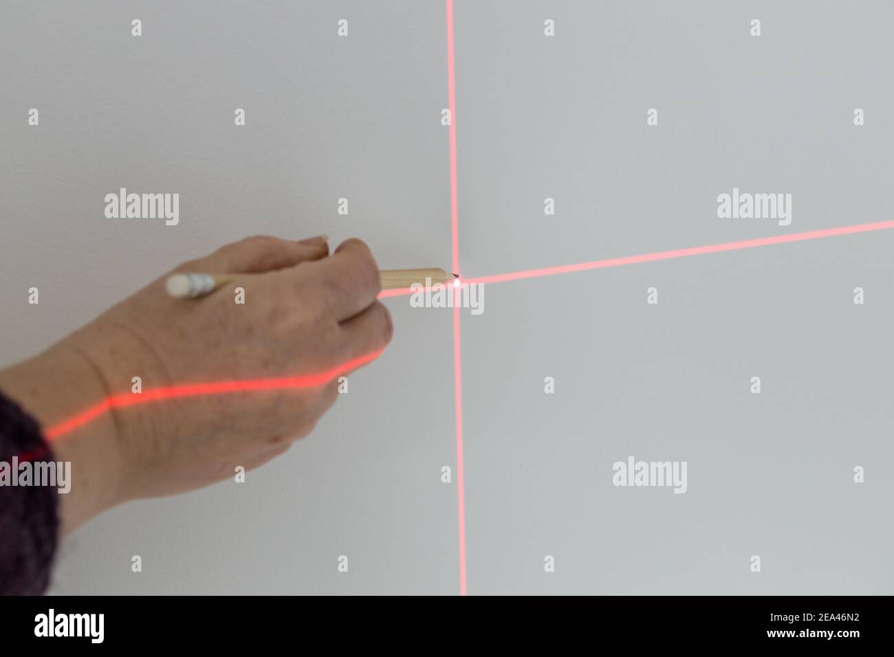 A specialist marks a point on a wall with an electronic laser Stock ...