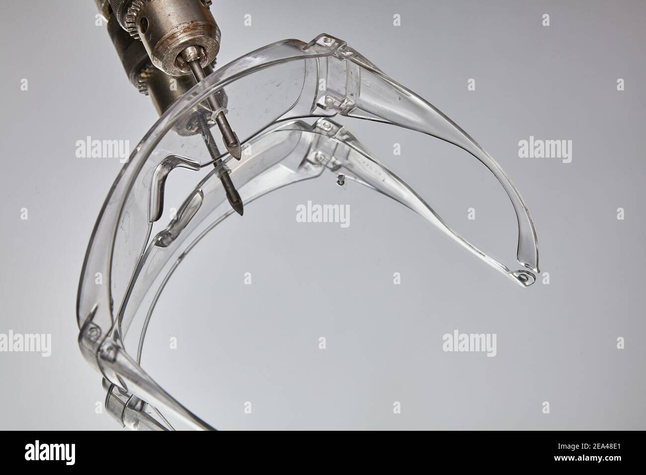 Locksmiths safety goggles are damaged by glass drill bit while drilling ...
