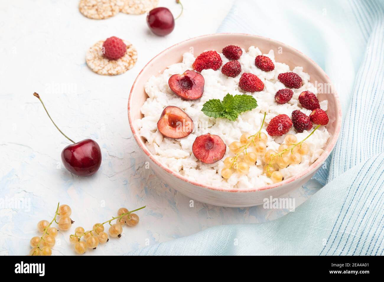 Rice flakes porridge with milk and strawberry in ceramic bowl on white ...