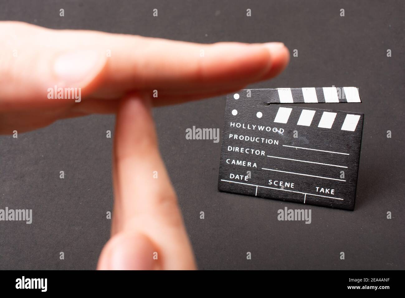 Hand holding movie clapper on a dark background Stock Photo - Alamy