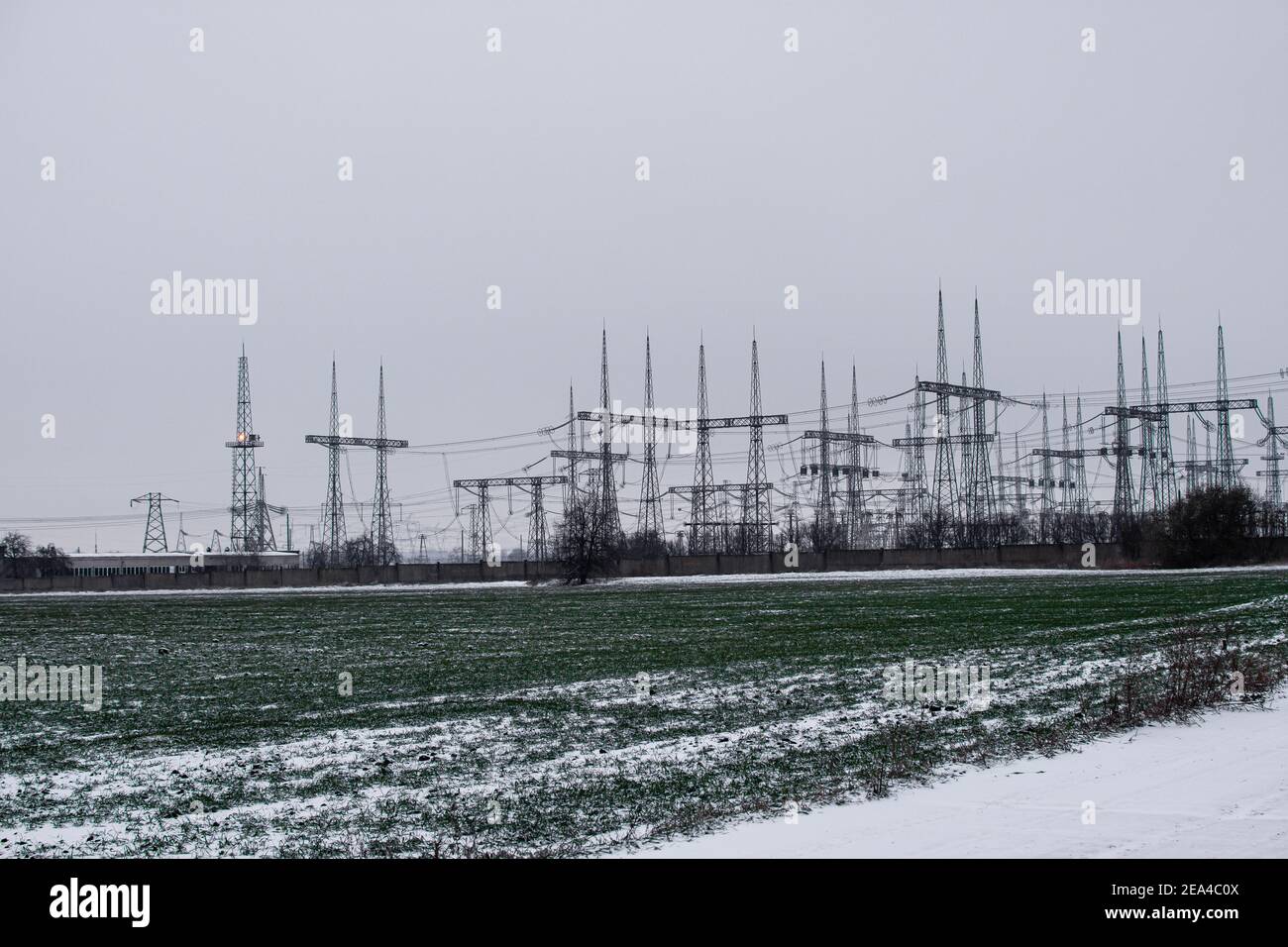 Electric substation on the background of a green field with winter ...