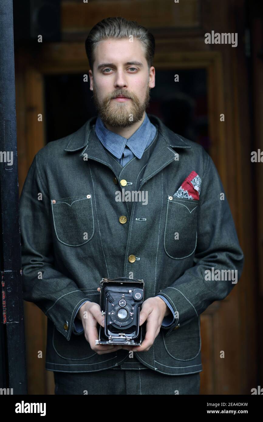 GREAT BRITAIN / England /London / Young man wearing denim jeans holding ...