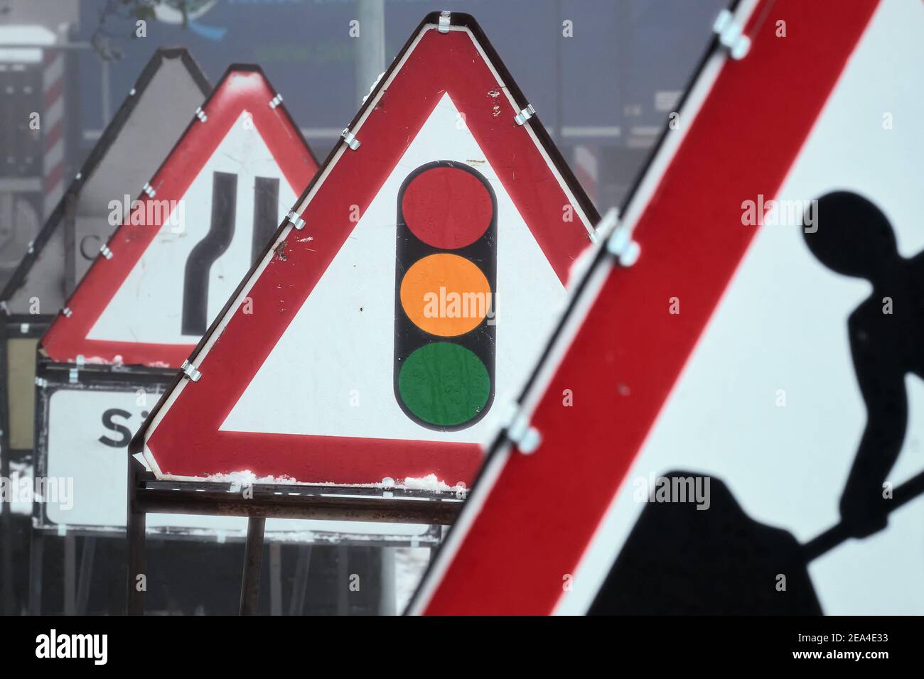 Road signs on the winter road. Signs Traffic light and Roadworks ...