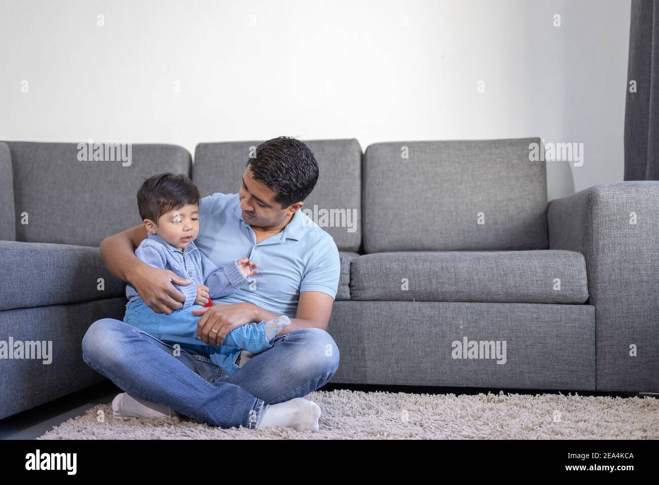 Mexican father and son playing on the carpet at home Stock Photo - Alamy