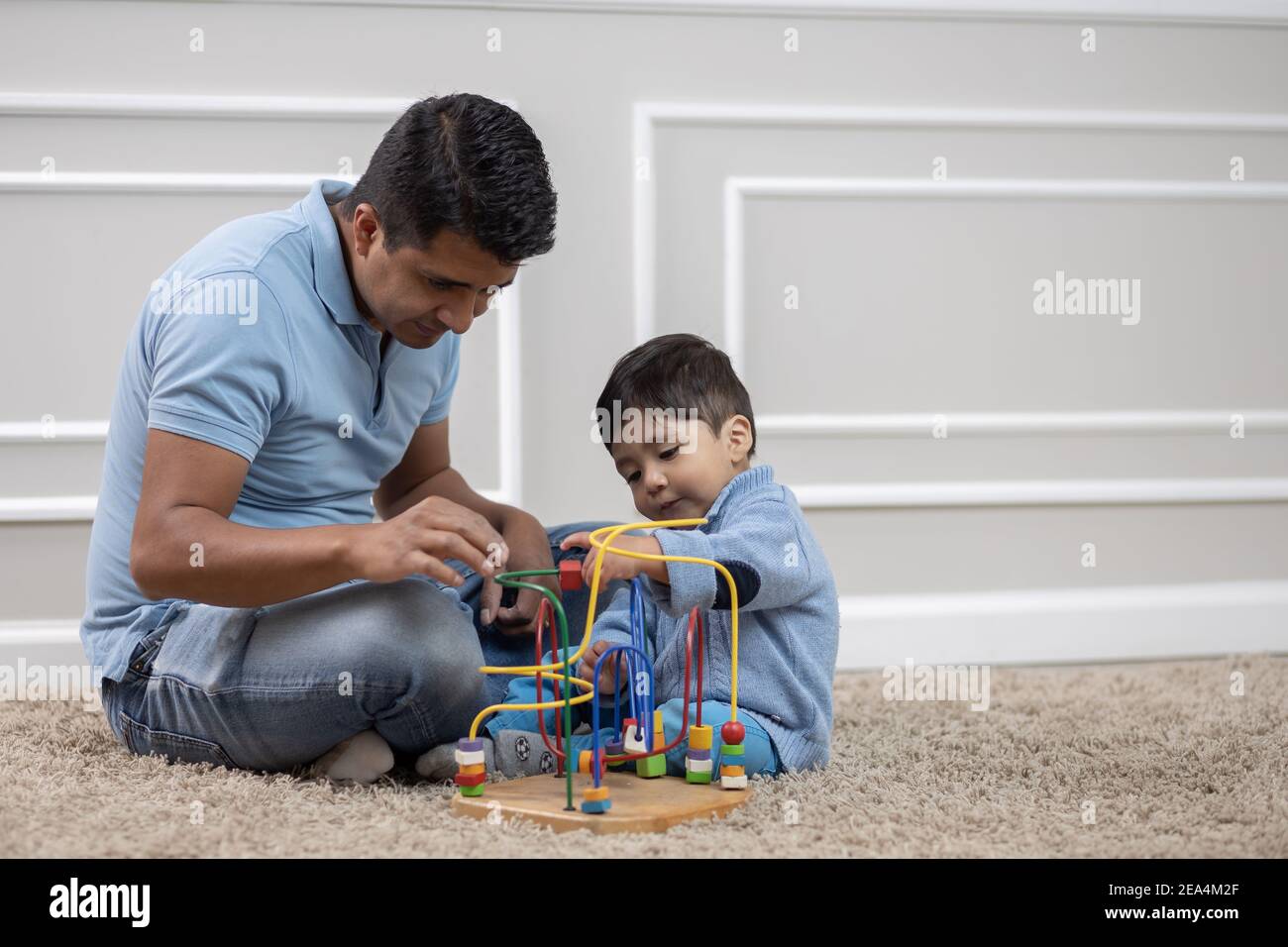 Mexican father and son playing on the carpet at home Stock Photo - Alamy