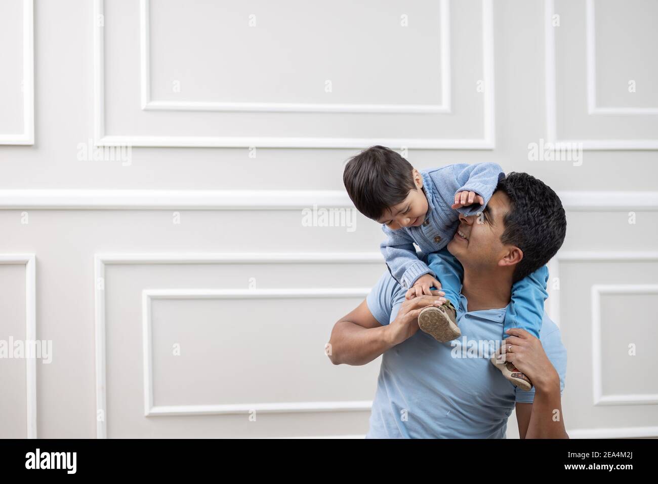 Mexican father and son happily playing at home Stock Photo - Alamy